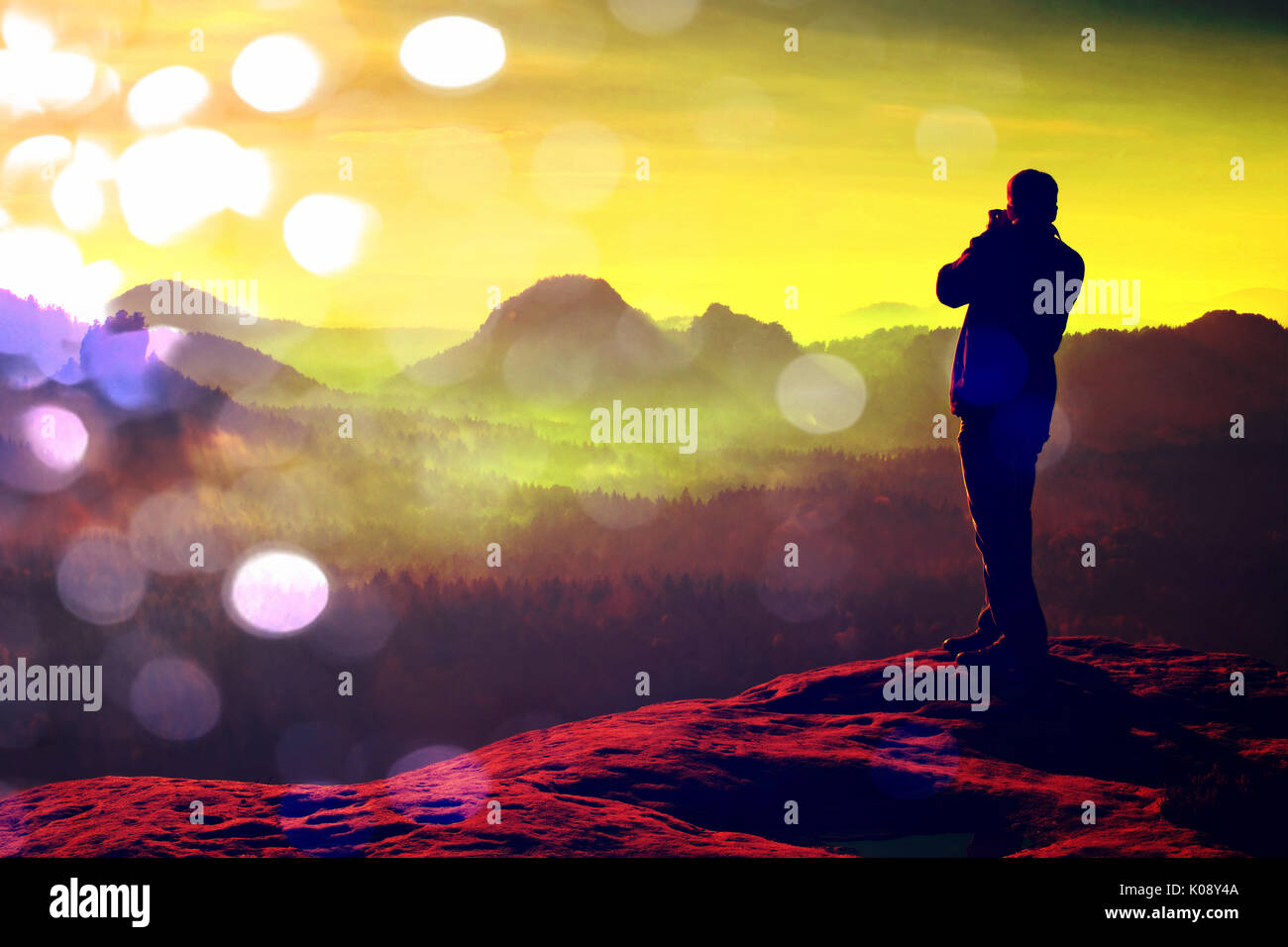 Film grain effect. Photographer takes photos with big camera on peak of ...