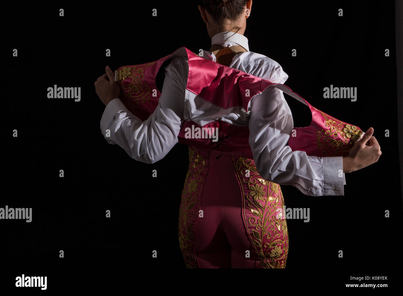 Woman bullfighter by dressing with vest on your back on a black ...