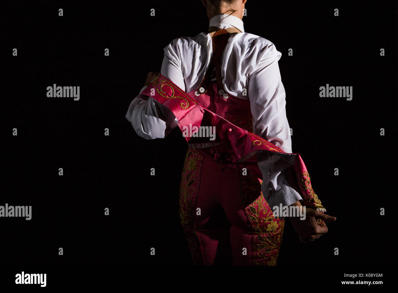 Woman bullfighter by dressing with vest on your back on a black ...