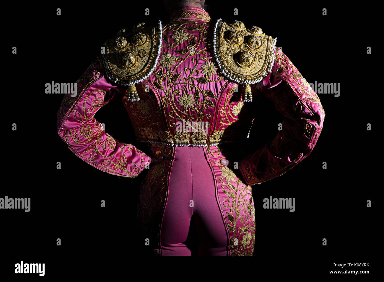 Woman bullfighter with pink costume back on black background Stock ...