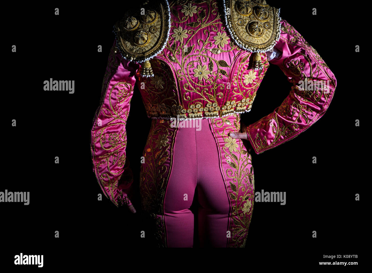 Woman bullfighter with pink costume back on black background Stock ...