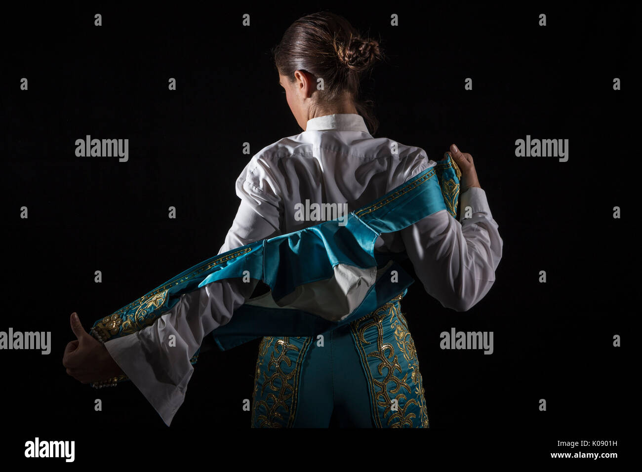 Woman bullfighter by dressing with vest on your back on a black ...