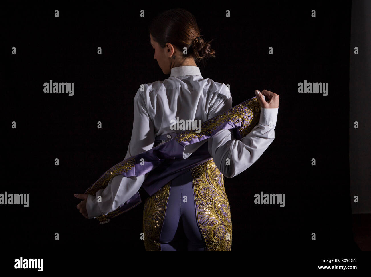 Woman bullfighter by dressing with vest on your back on a black ...
