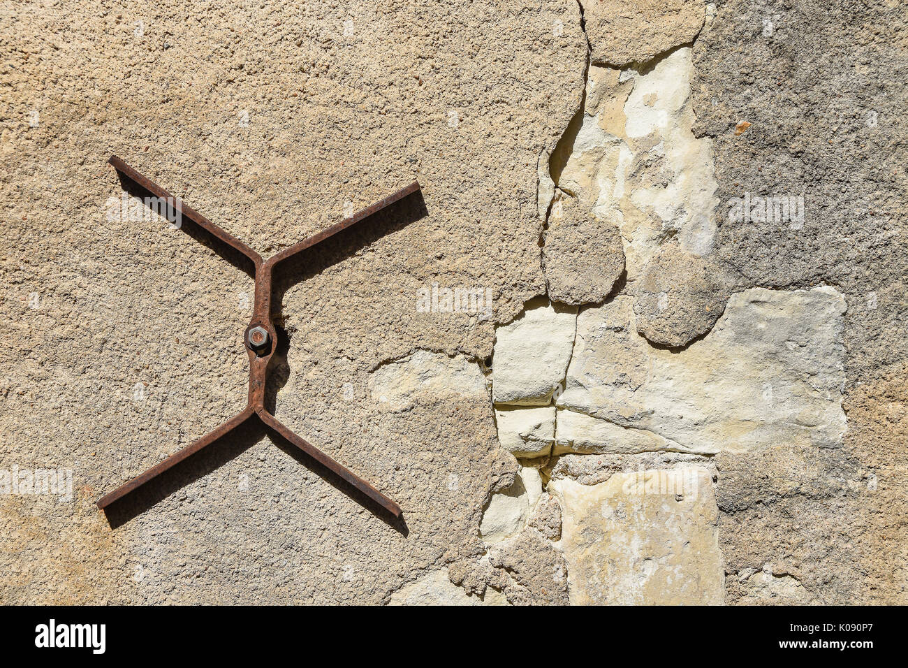 Cracked stone wall next to metal tie-rod and strengthening bracket ...