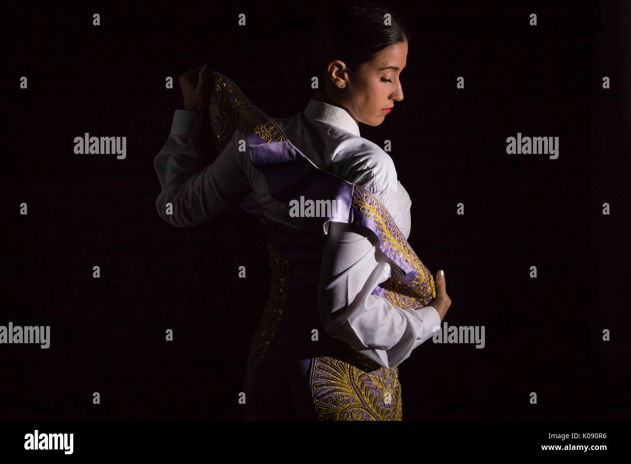 Woman bullfighter by dressing with vest on your back on a black ...