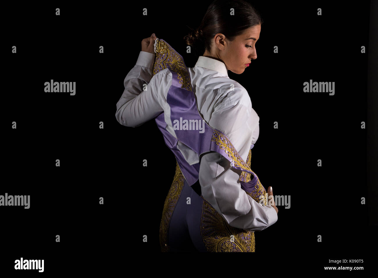 Woman bullfighter by dressing with vest on your back on a black ...