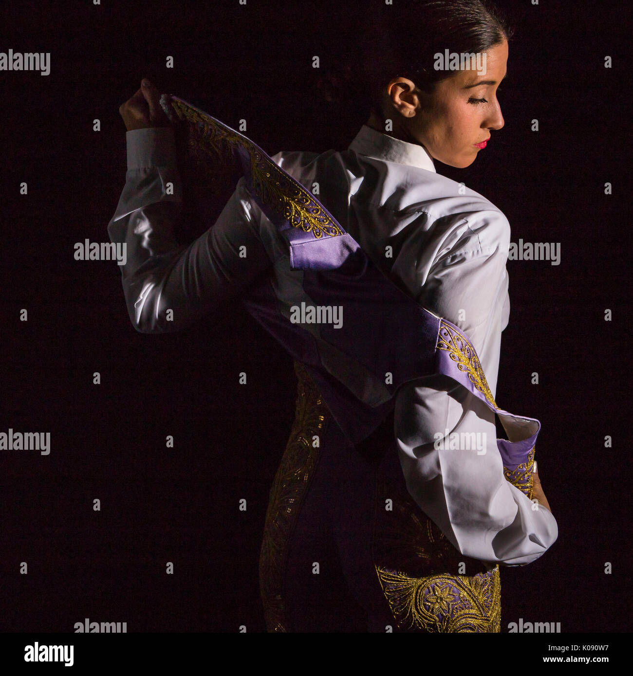 Woman bullfighter by dressing with vest on your back on a black ...