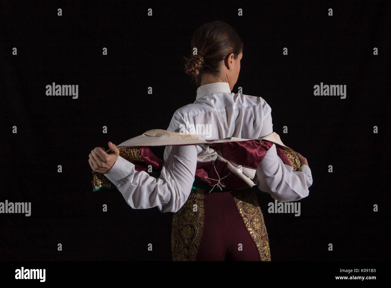 Woman bullfighter by dressing with vest on your back on a black ...