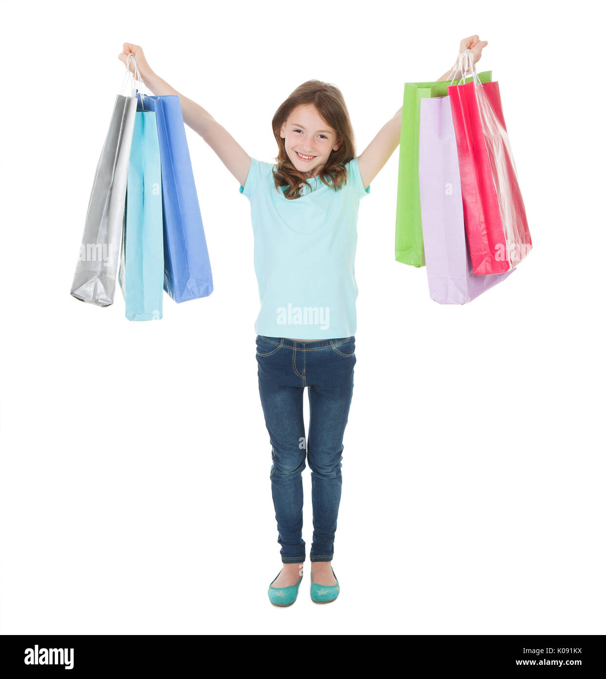 Full length portrait of smiling girl carrying shopping bags isolated ...