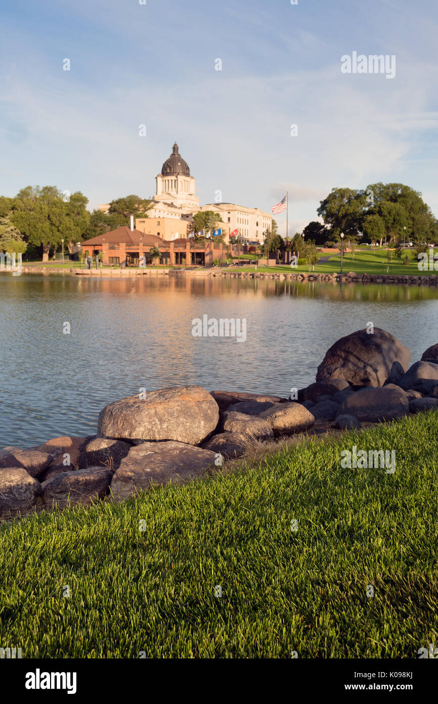 Water reflects the American Flag waving in front of the capitol dome in ...