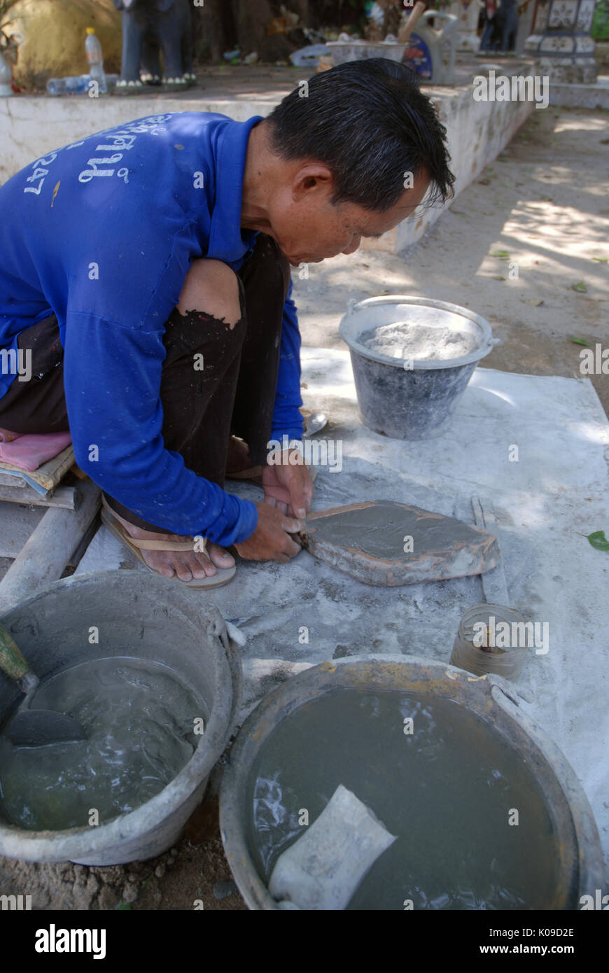 Man making concrete decorations as part of repair works to the temple ...