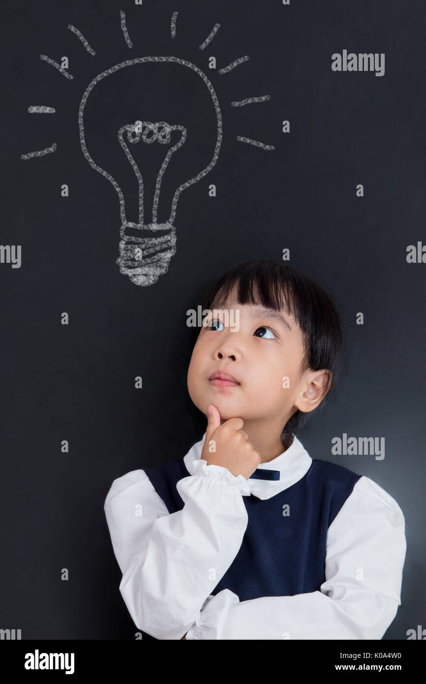 Asian Chinese little girl thinking with bulb sketch on blackboard in ...