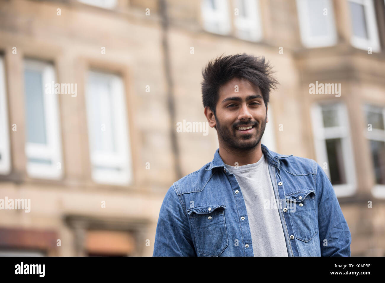 Portrait of a trendy Indian man standing in an urban man in street ...
