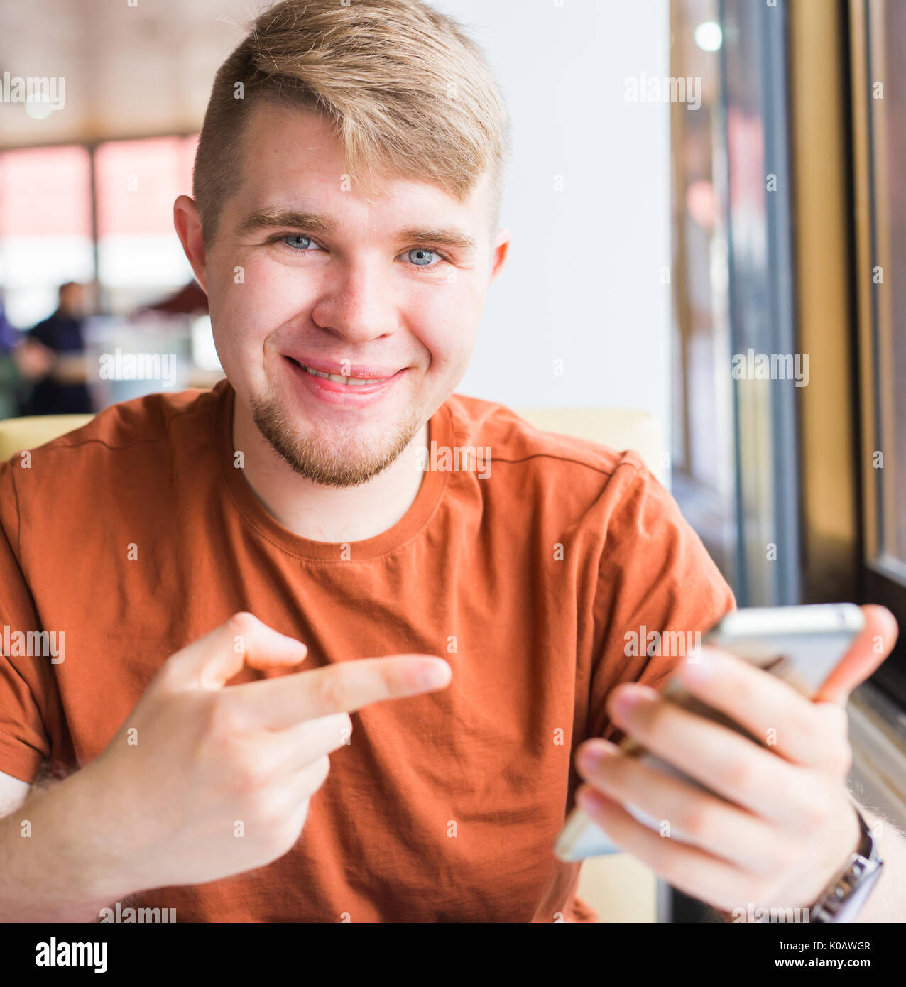 technology, communication and people concept - Young man holding ...