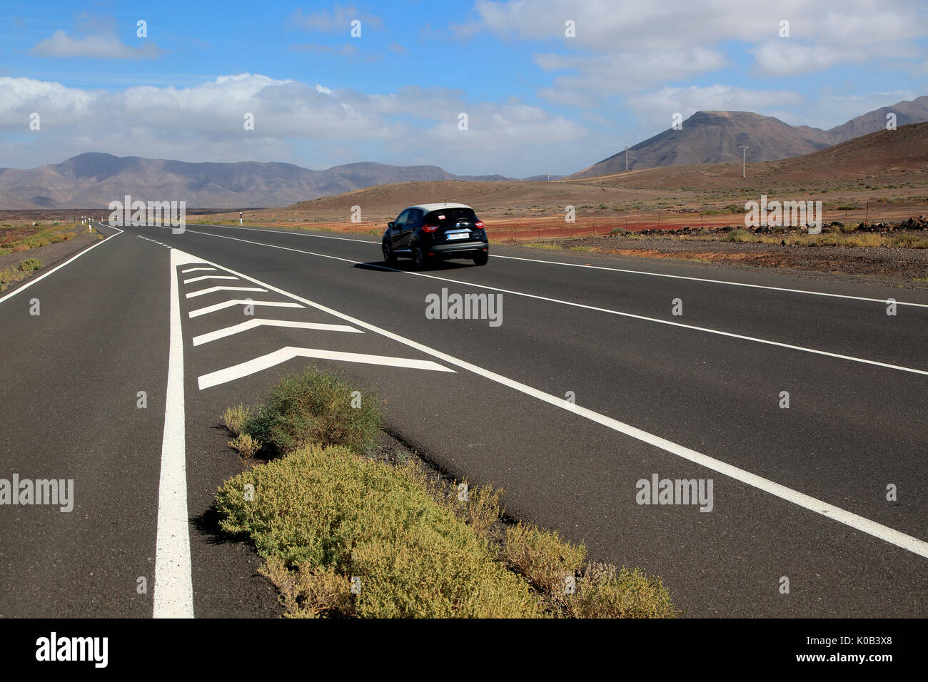 Chevron road lines on main highway through Malpaís Grande national park ...