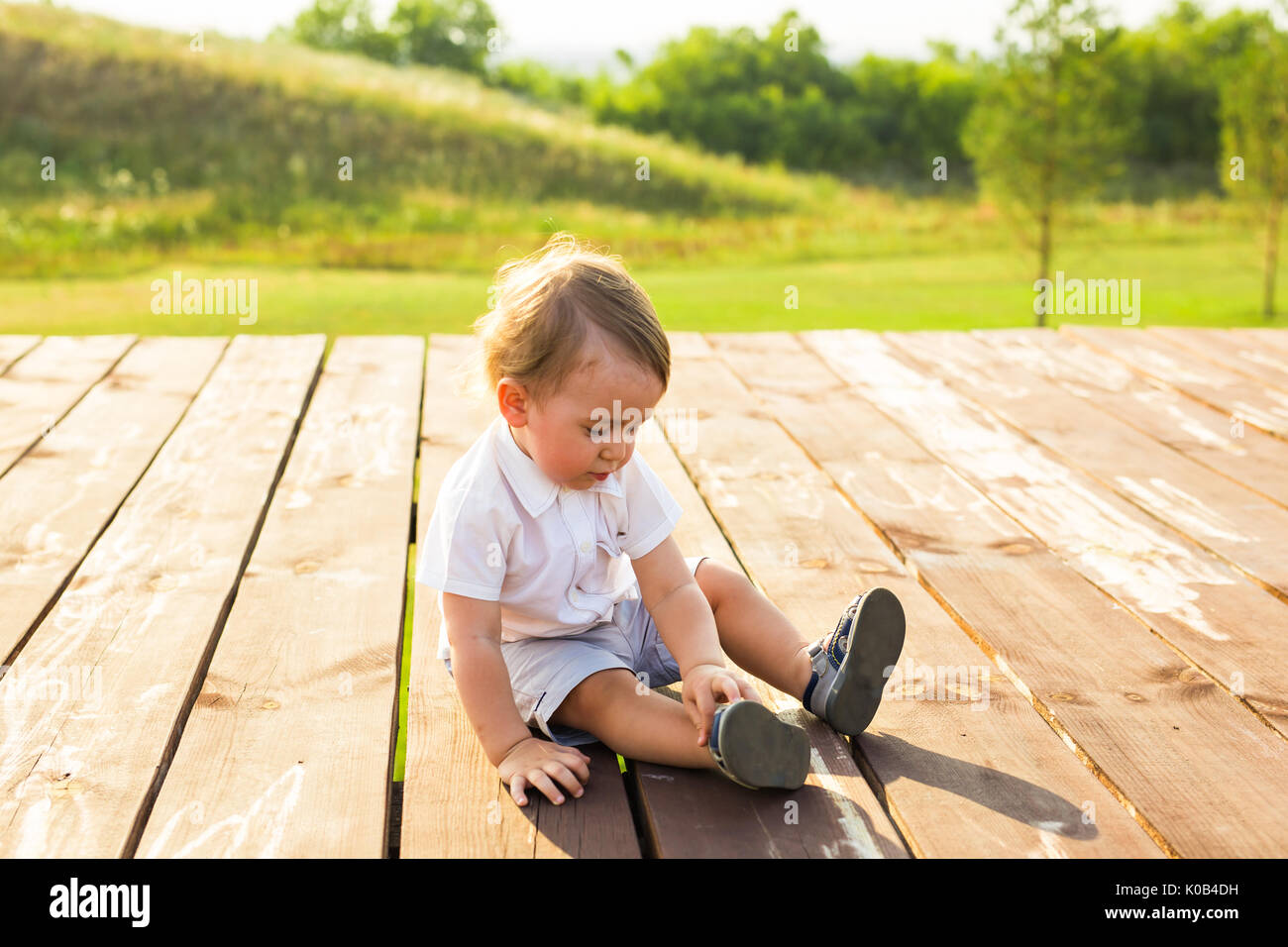 smiling boy in the field at sunny summer morning. boy in white shirt ...