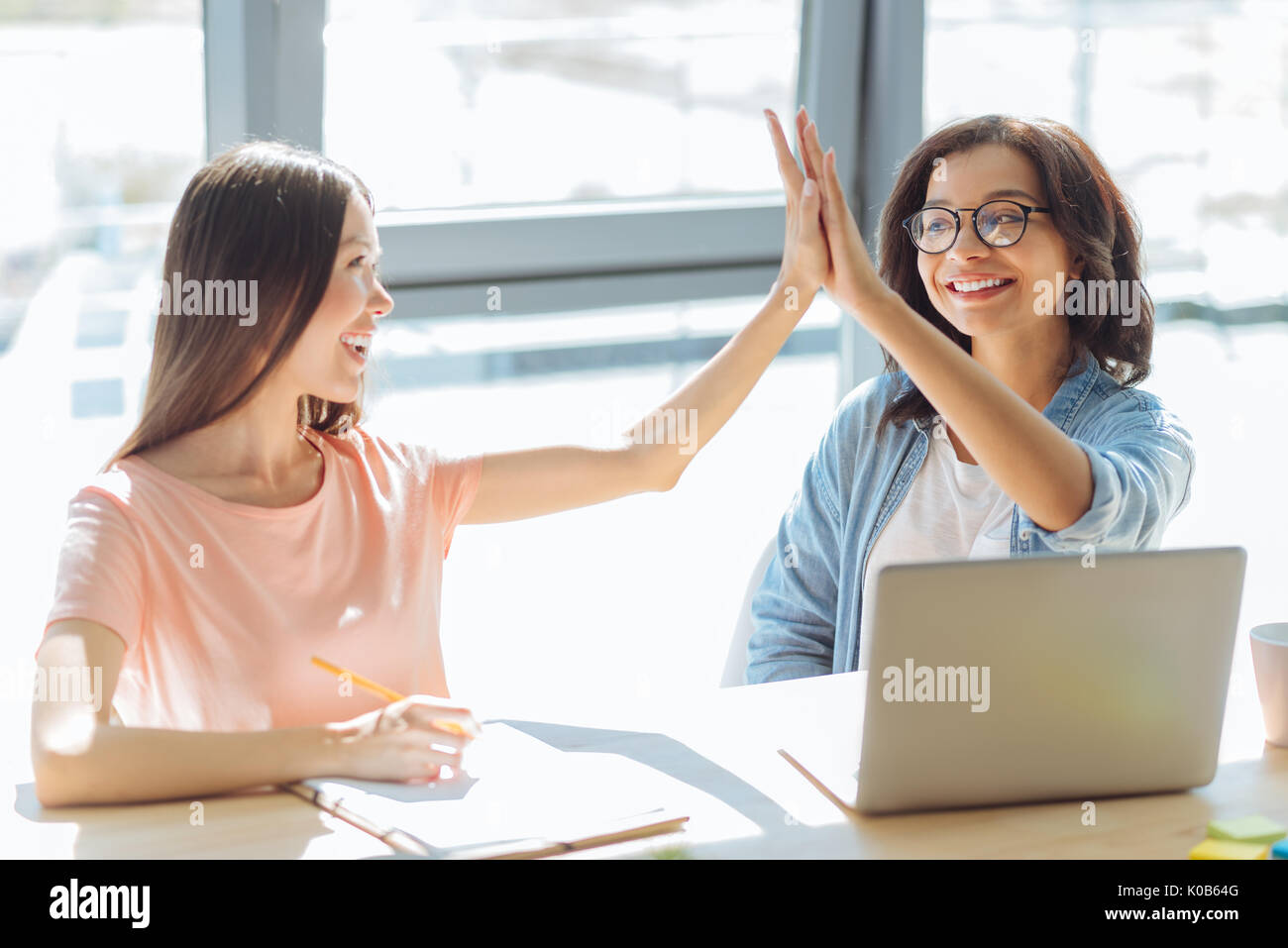 Delighted positive students giving high five Stock Photo - Alamy