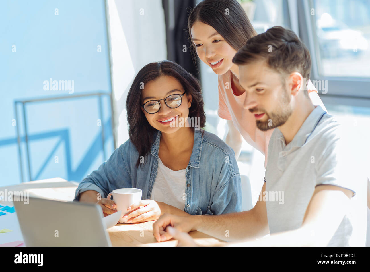 Positive young people working together Stock Photo - Alamy
