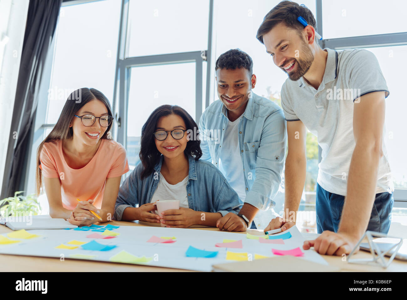Happy young people looking at the poster Stock Photo - Alamy