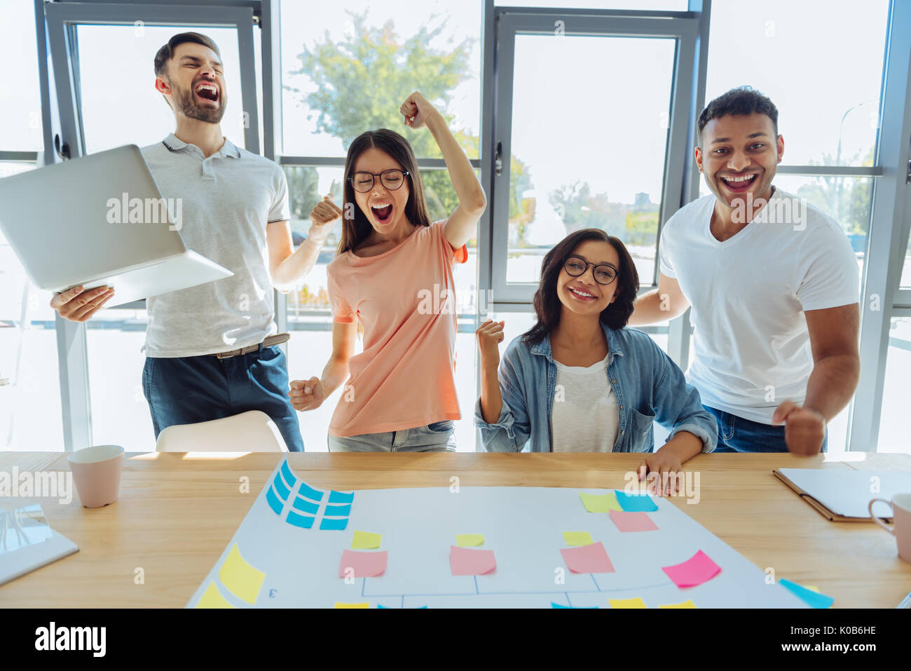 Delighted young team showing their emotions Stock Photo - Alamy