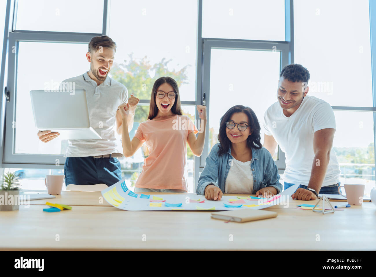 Happy joyful team finishing their work Stock Photo - Alamy