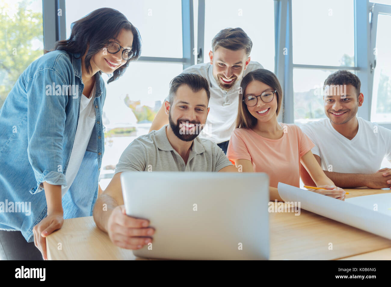 Happy positive people looking at the laptop screen Stock Photo - Alamy