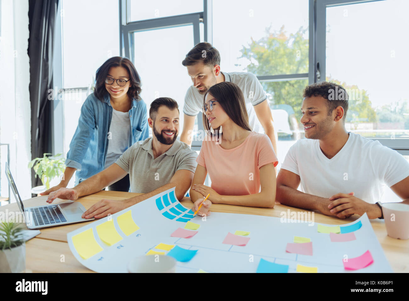 Happy young team working in the office Stock Photo - Alamy