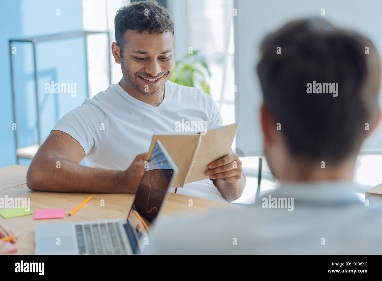 Happy smart man opening a notebook Stock Photo - Alamy