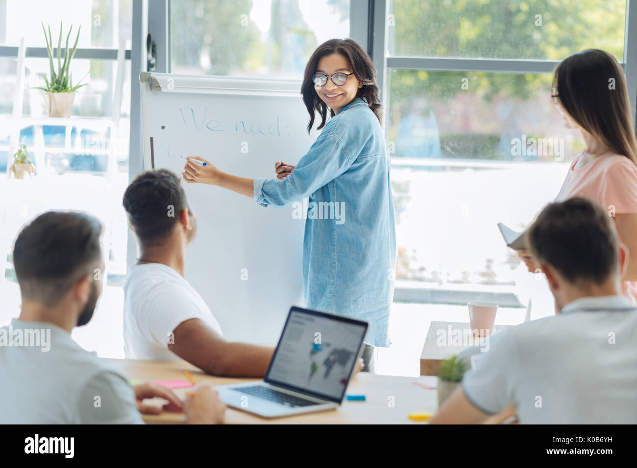 Positive delighted woman writing on the whiteboard Stock Photo - Alamy