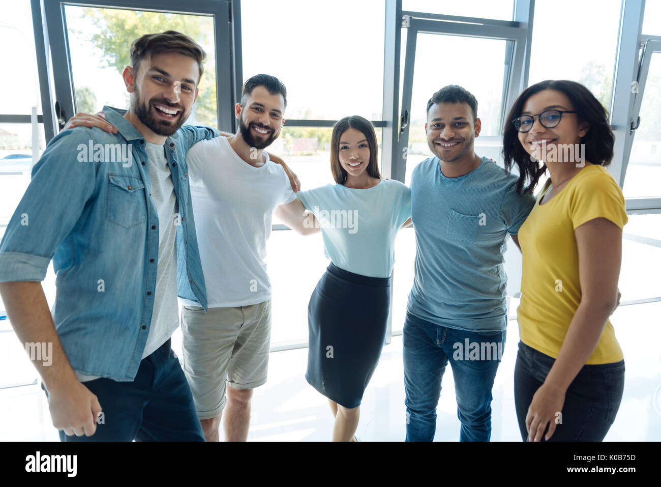 Happy young people looking at you Stock Photo - Alamy