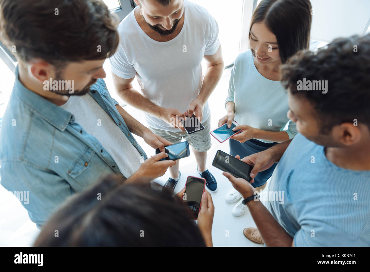 Happy young people typing messages Stock Photo - Alamy