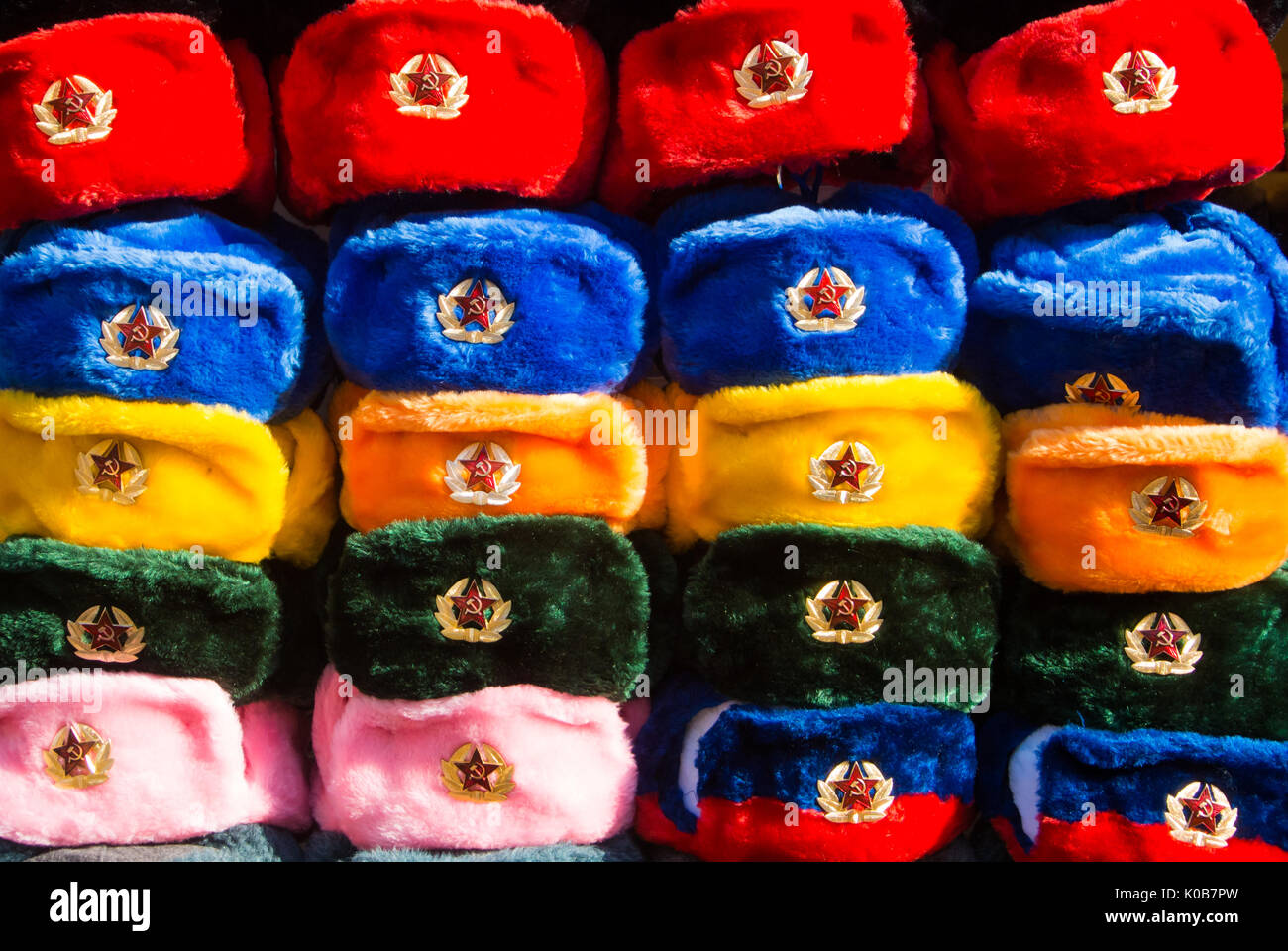 Rows of russian winter hats of different colors with army emblems at ...
