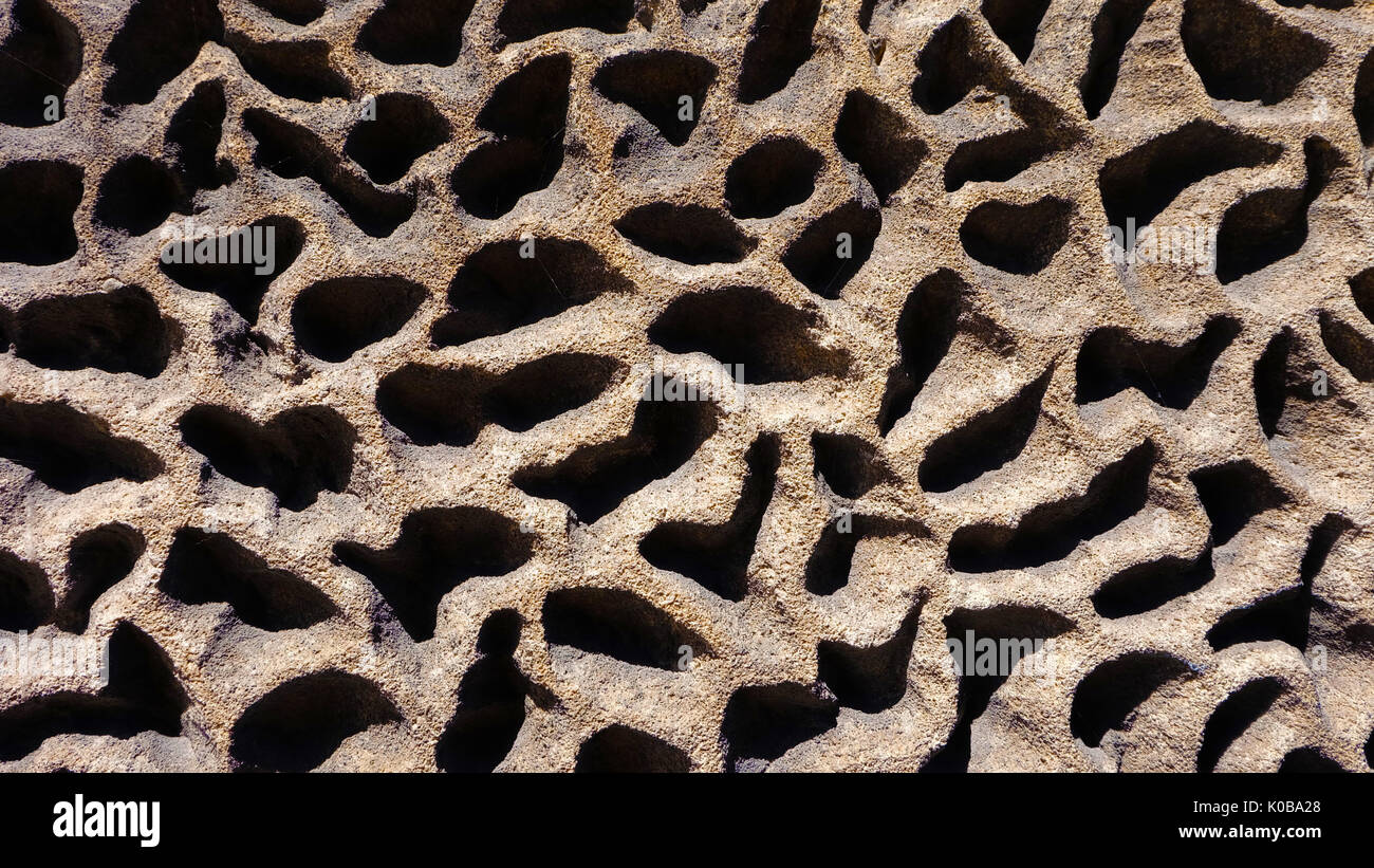 Background of concrete wall with deep holes, forming pattern with dark ...