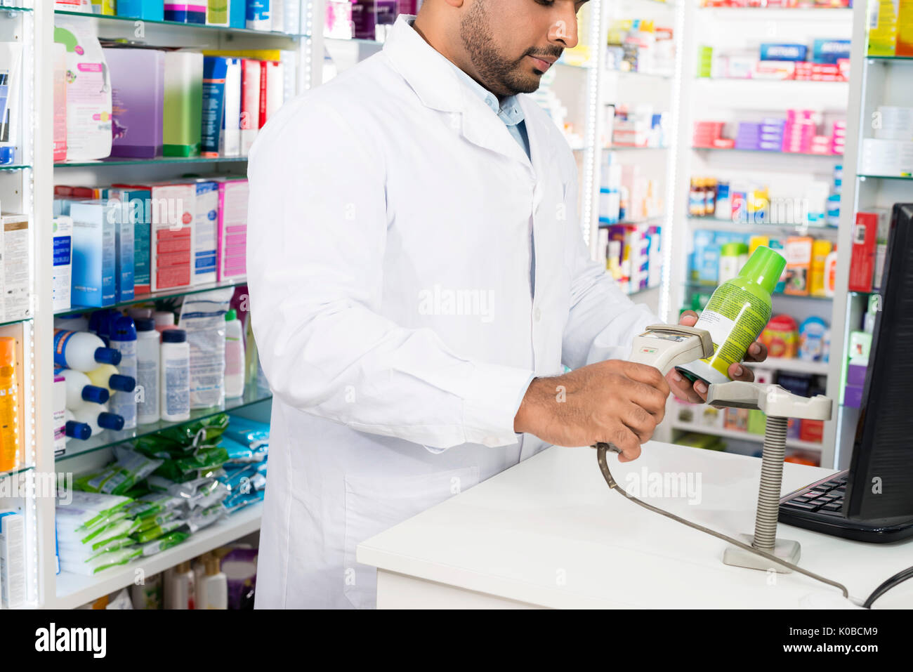 Chemist Scanning Barcode Of Product At Checkout Counter Stock Photo - Alamy