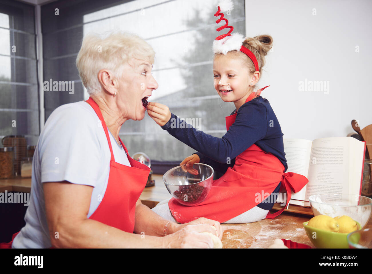 Girl feeding her grandmother with dried fruit Stock Photo - Alamy