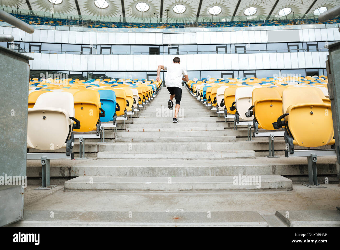Back view of a young sportsman running upstairs at the stadium Stock ...