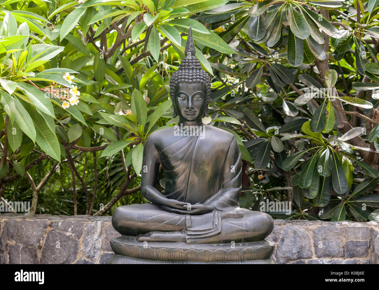 Metal buddha statue lotus pose in the garden Stock Photo - Alamy
