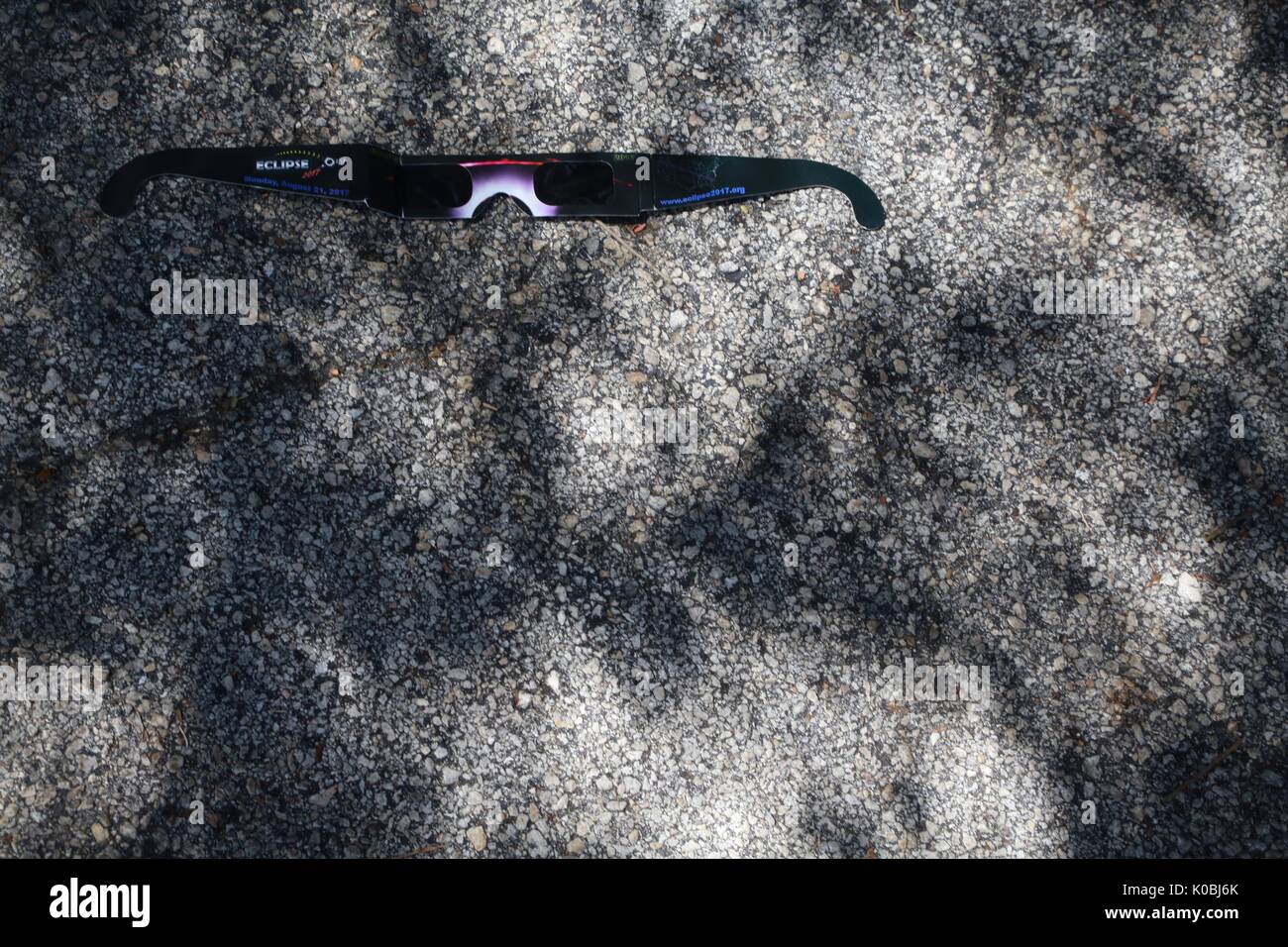 Solar Eclipse Viewing Glasses on Pavement Surrounded by Crescent-Shaped ...
