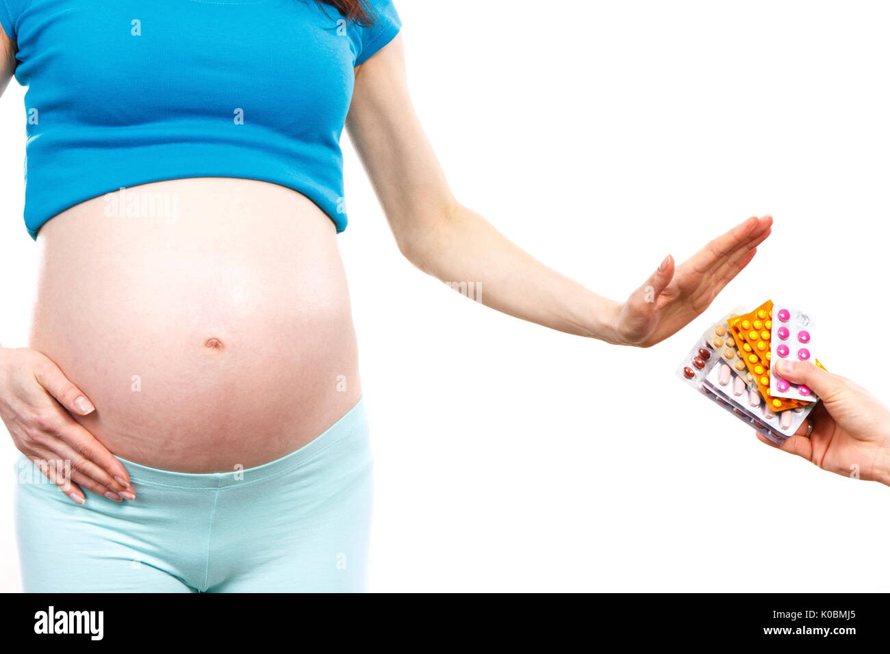 Woman in pregnant making stop gesture in front of medical tablets ...