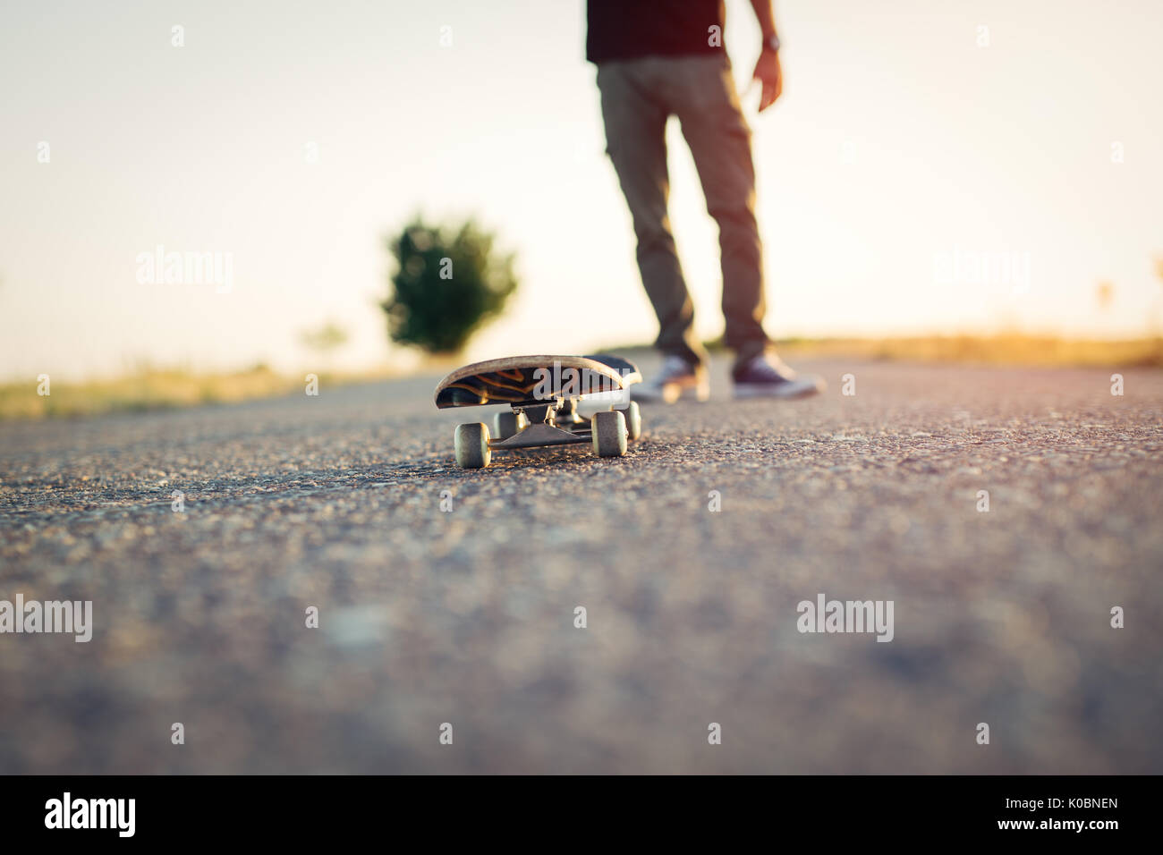 Skateboard on the street at sunset light Stock Photo - Alamy
