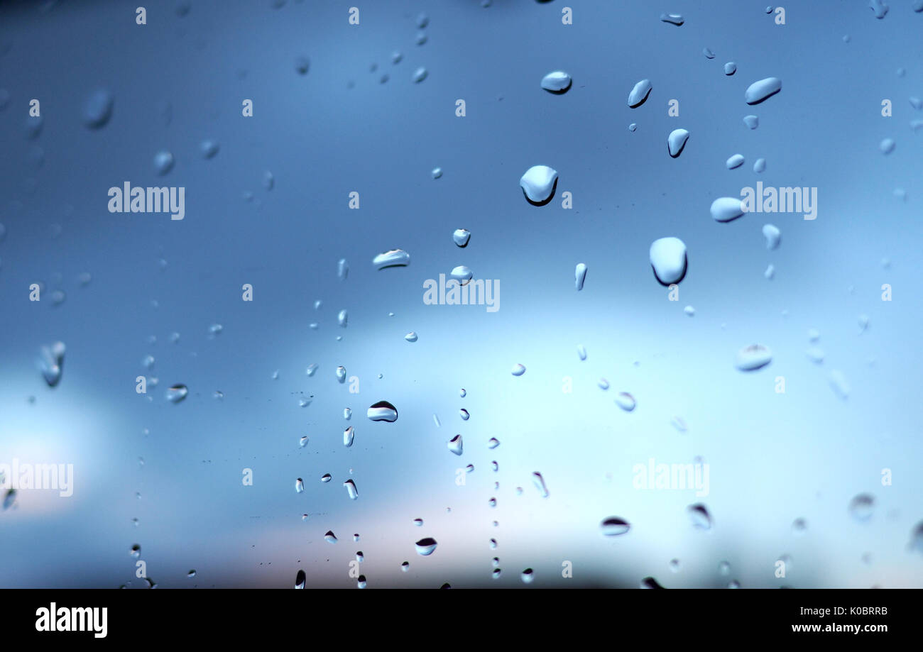 Window with raindrops, dark blue clouds behind Stock Photo - Alamy