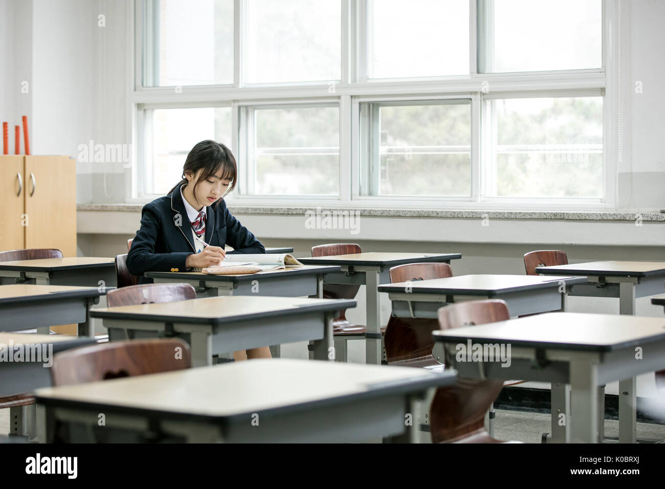 Portrait of school girl sitting in classroom Stock Photo - Alamy