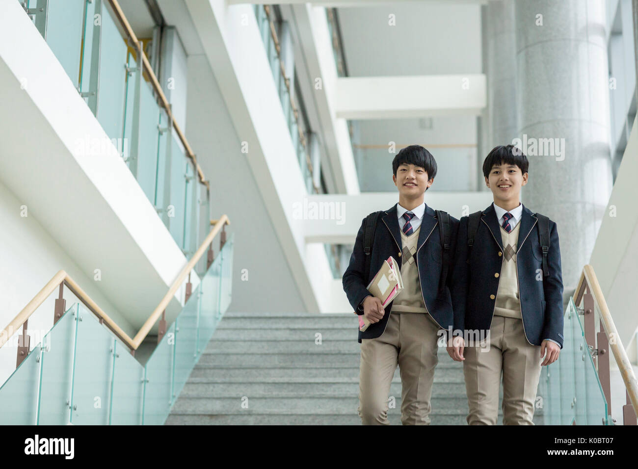 Two smiling school boys going downstairs at school Stock Photo - Alamy