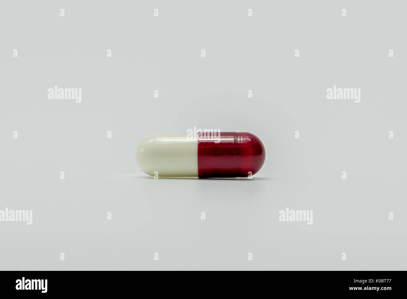 White, red capsule pills isolated on white background Stock Photo - Alamy