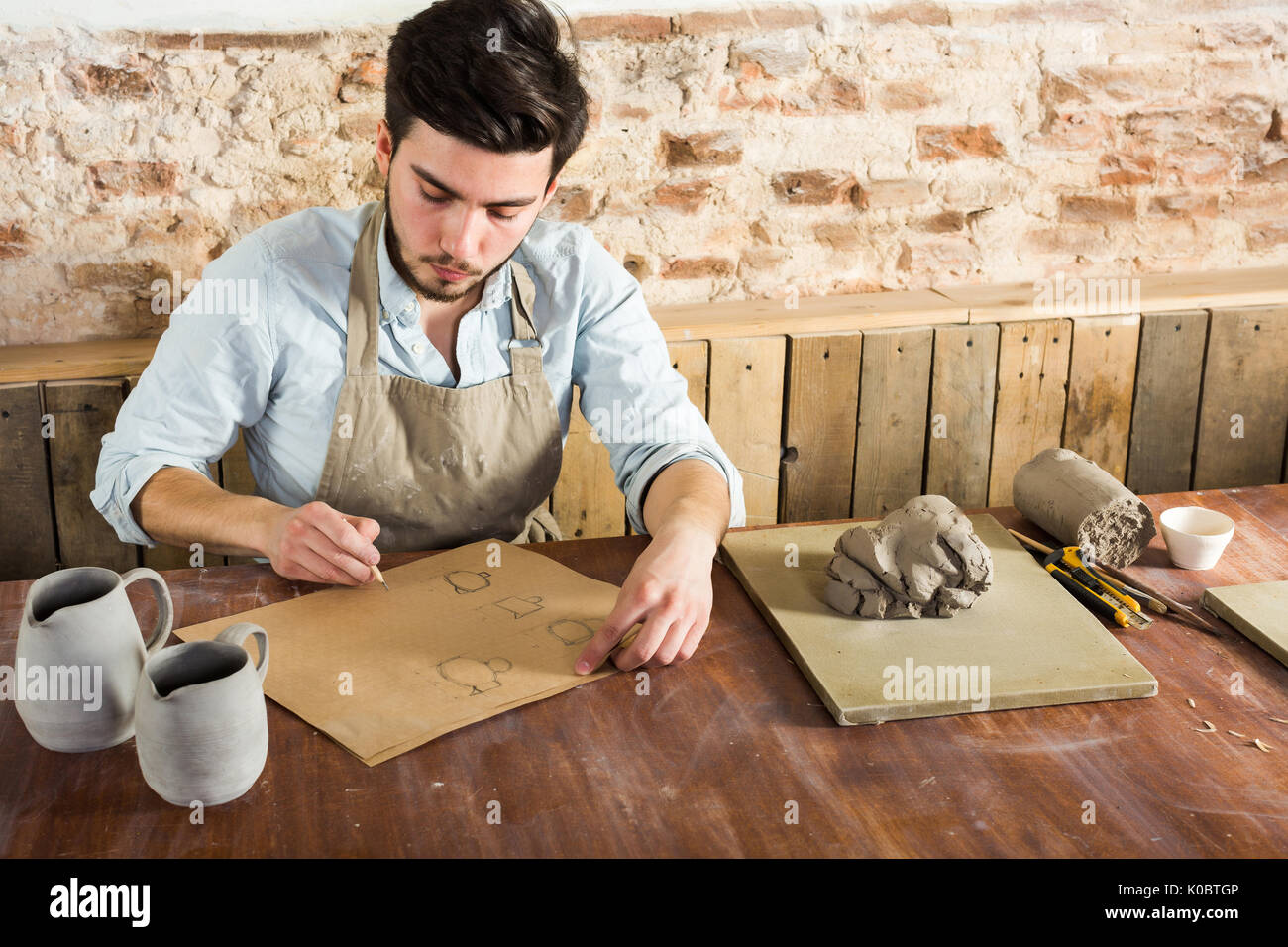 potter workshop, artisan tools, ceramics art concept - young man works ...