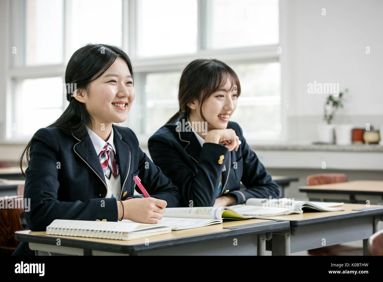 Portrait of two smiling school girls in classroom Stock Photo - Alamy