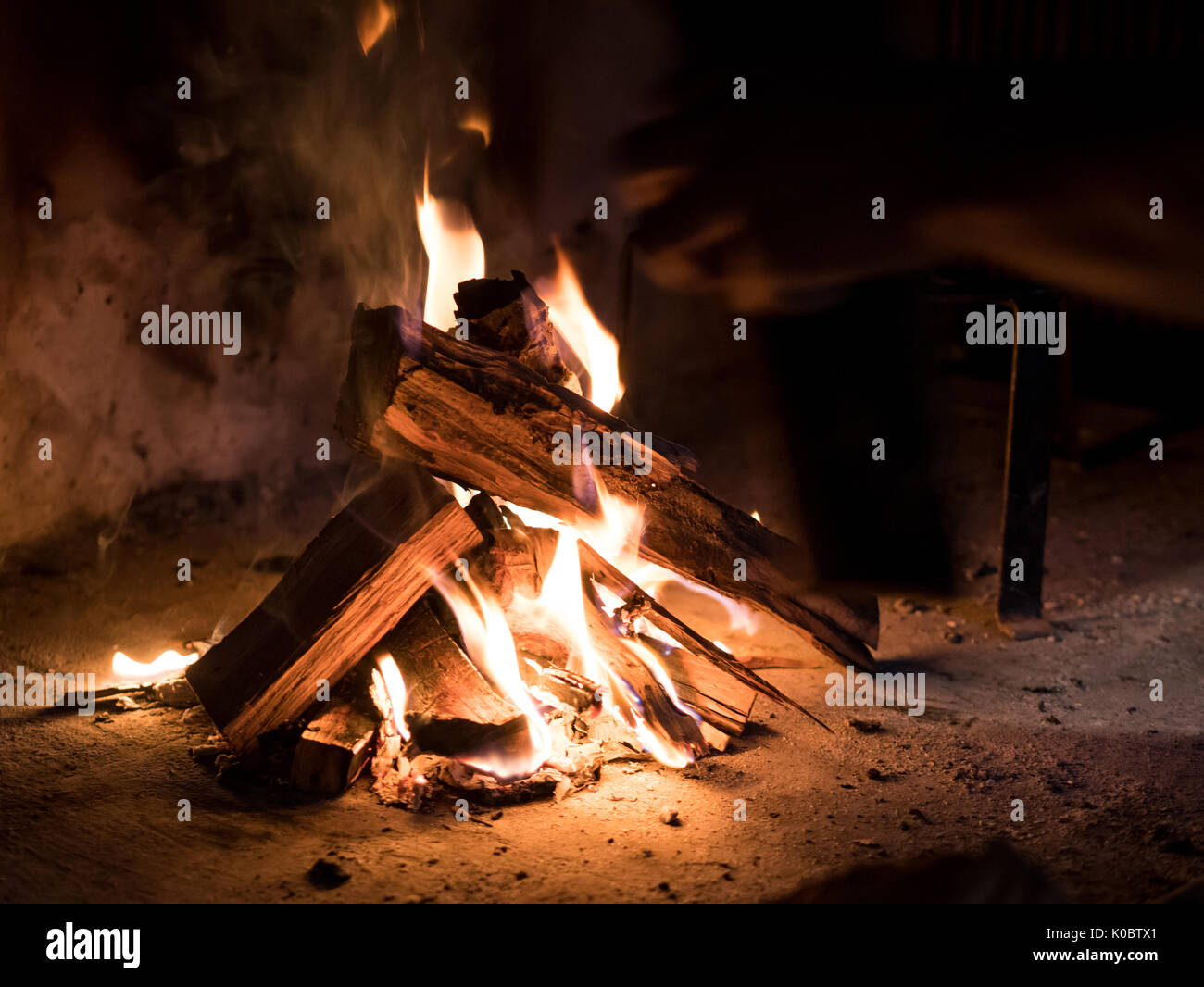 Man preparing wood fire in indoor fireplace Stock Photo - Alamy