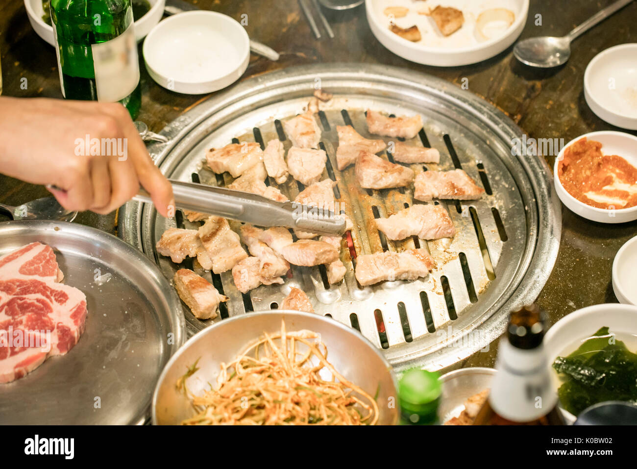 Hand roasting pork at get-together Stock Photo - Alamy