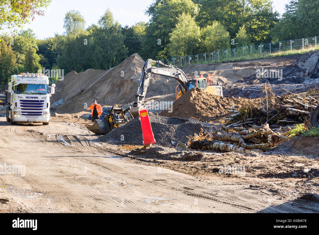 Heavy duty excavators at building site digging and loading trucks ...