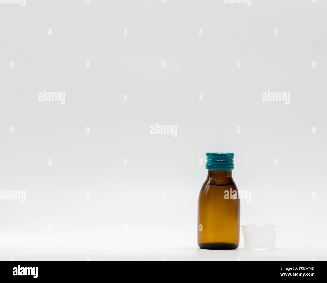 Antipyretic syrup in amber bottle with blank label and a plastic ...